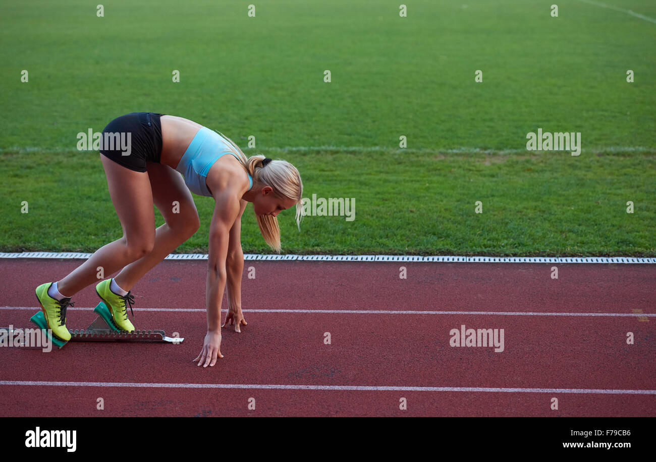 athlete woman group running on athletics race track on soccer stadium ...