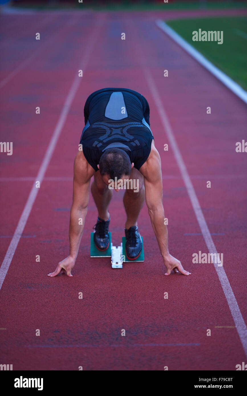 Sprinter leaving starting blocks on the running track. Explosive start ...