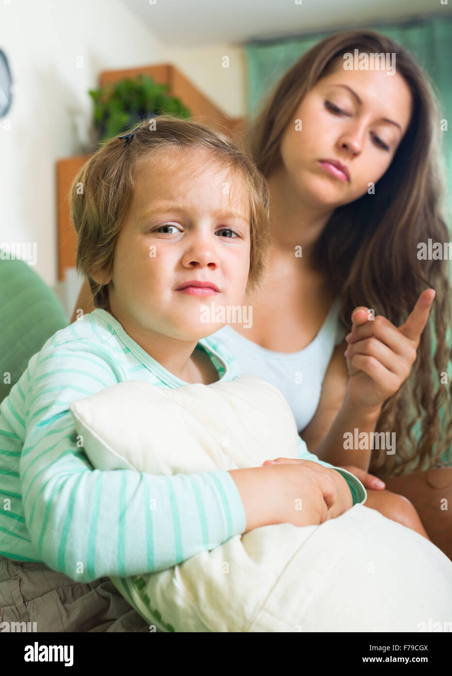 Young mother berating crying child at home. Focus on girl Stock Photo ...