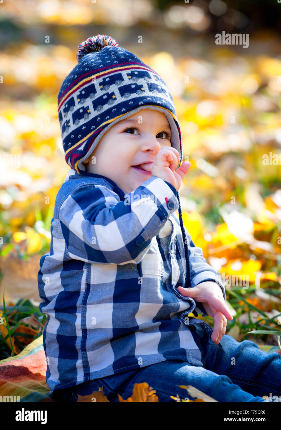 Portrait of 8 months old baby boy enjoying a fall day in the park ...