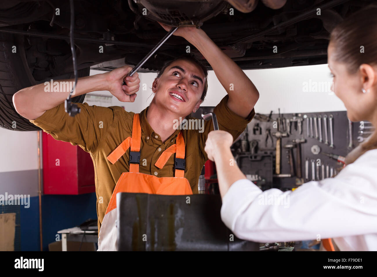 Handsome mechanic and beautiful female assistant working in the auto ...