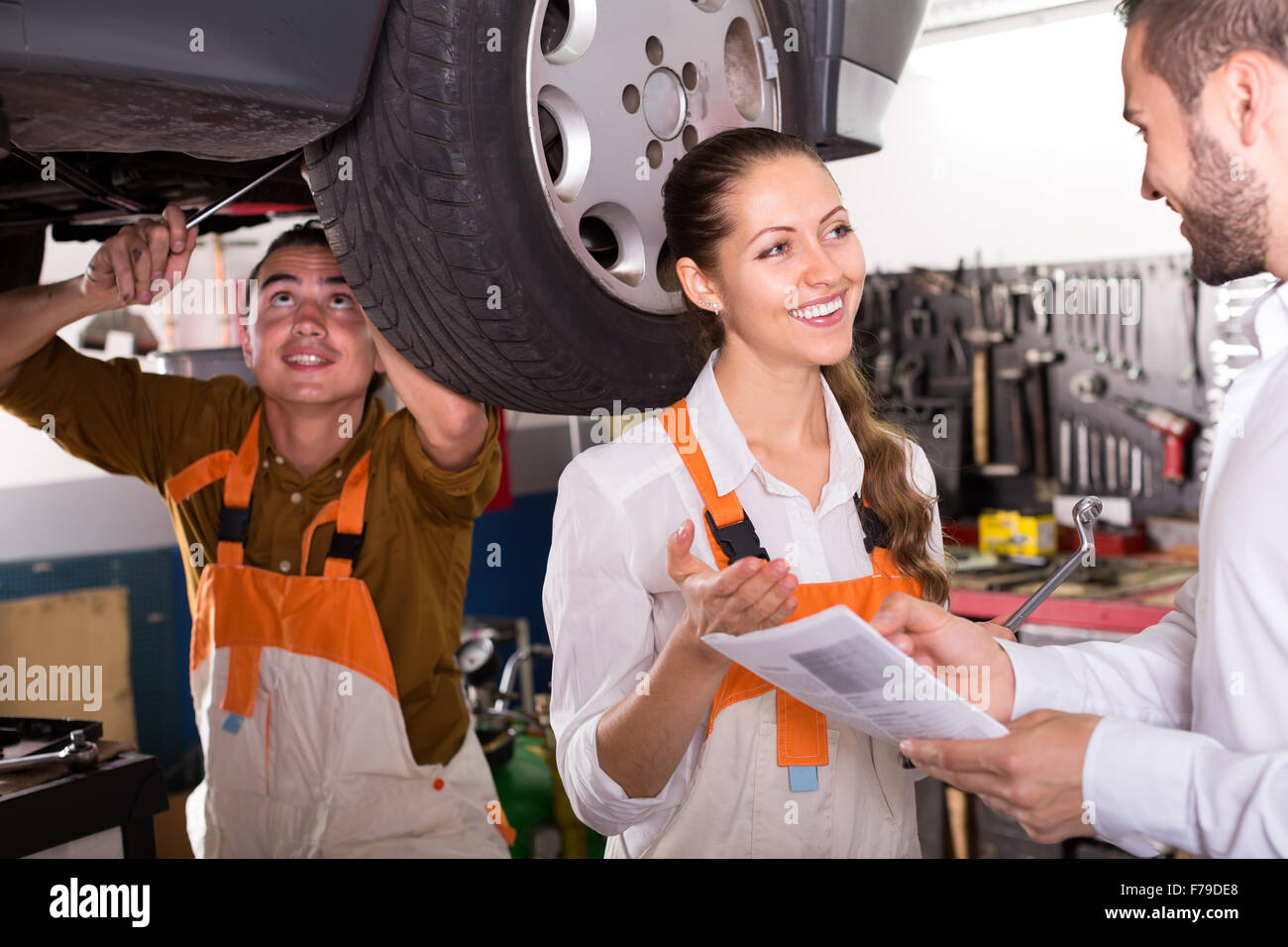 Service crew and driver standing near car and smiling Stock Photo - Alamy