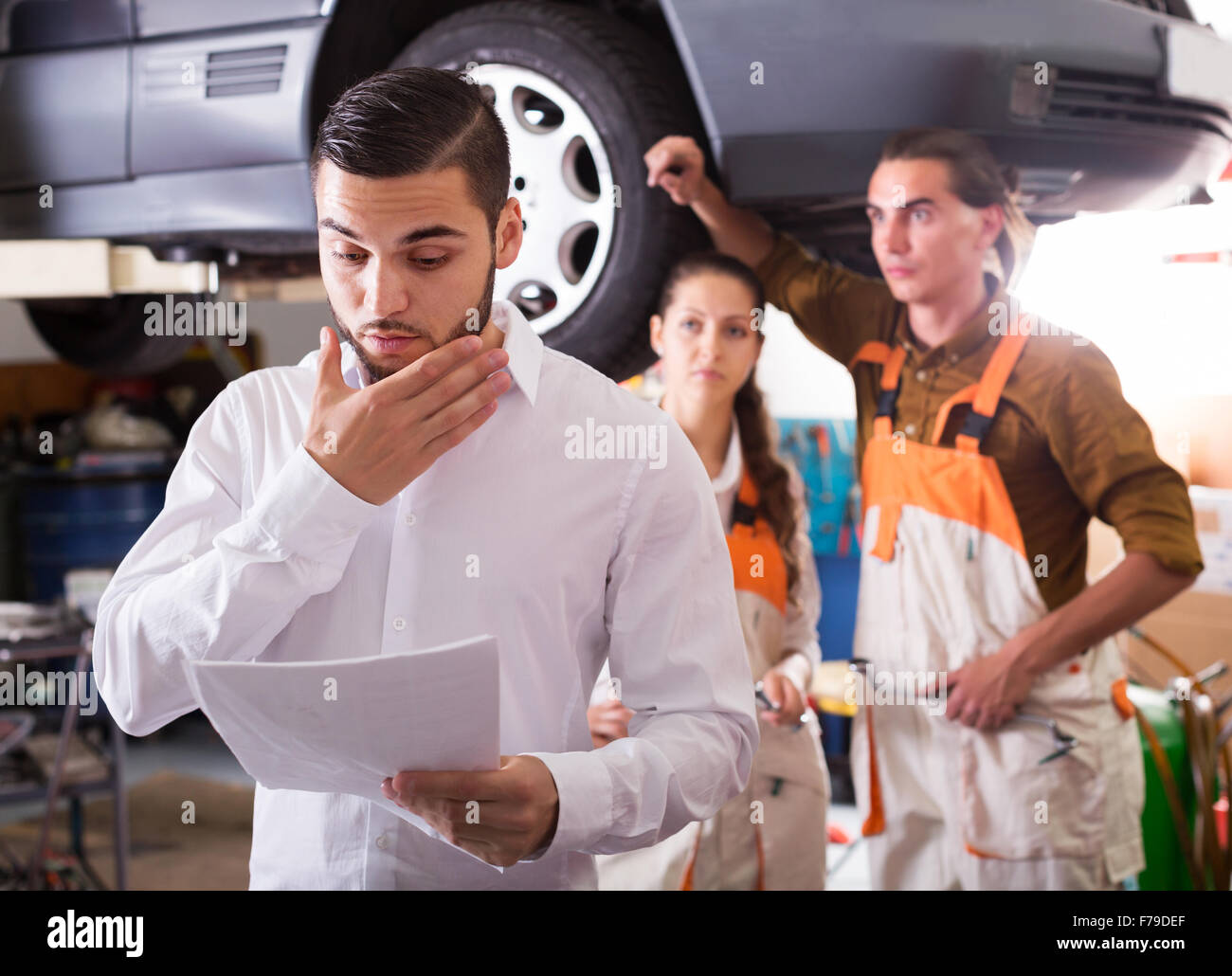 Two mechanics trying to cheat client at workshop Stock Photo - Alamy