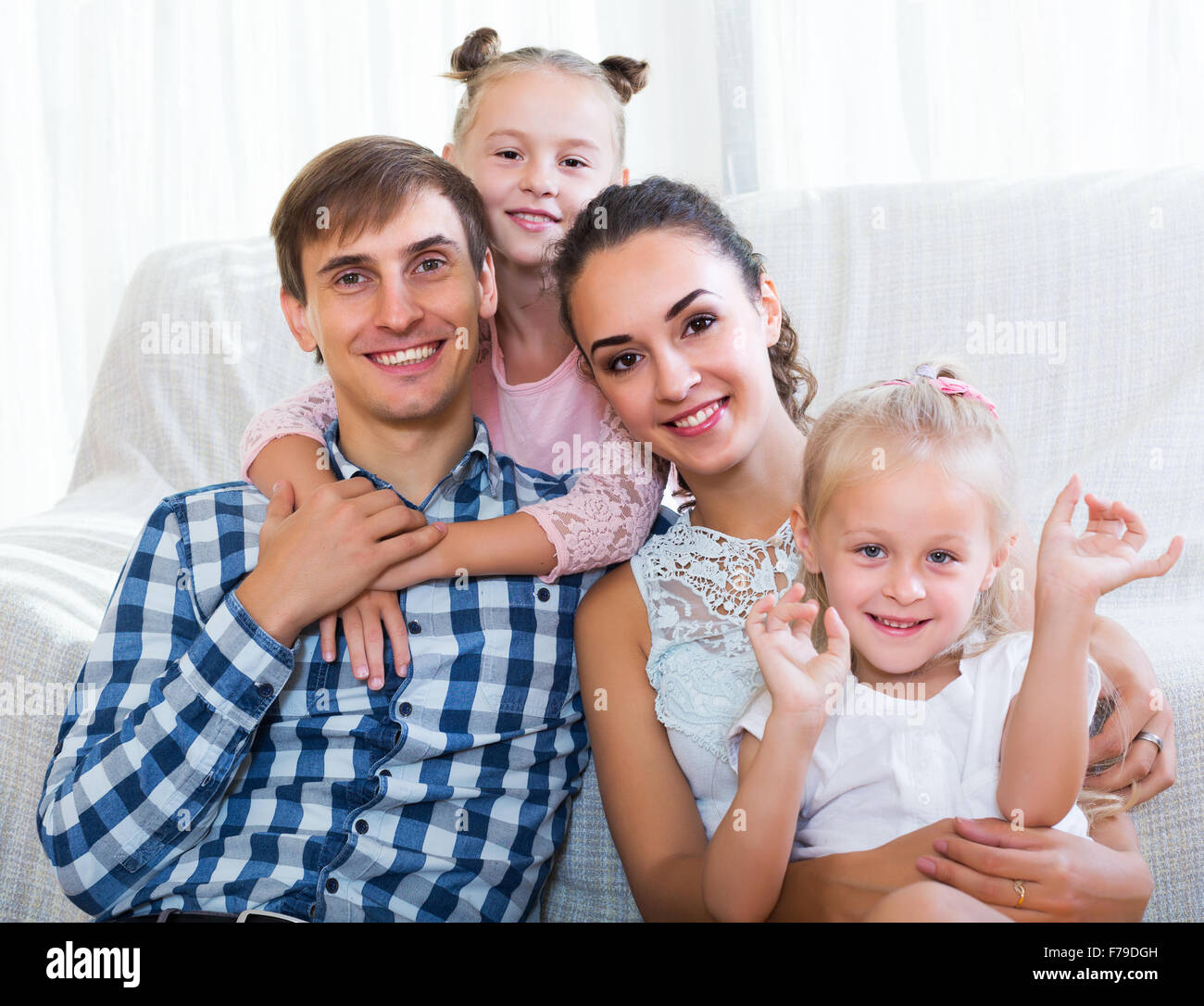 Portrait of relaxed happy family of four posing at home Stock Photo - Alamy