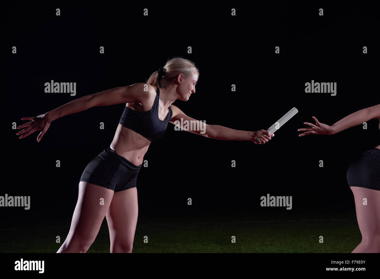 woman athletic runners passing baton in relay race Stock Photo - Alamy