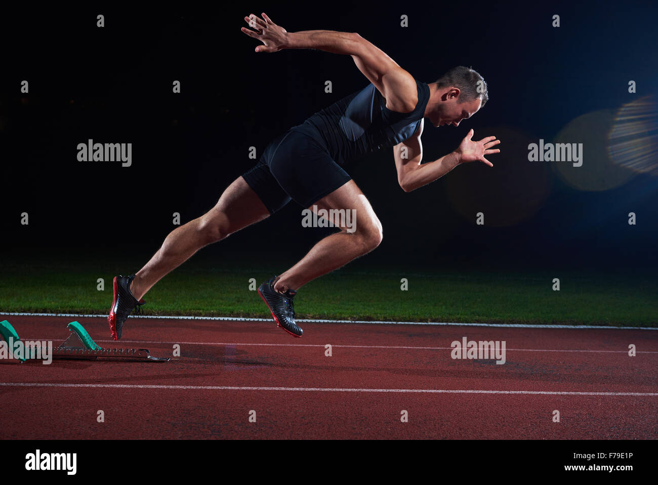 Sprinter leaving starting blocks on the running track. Explosive start ...