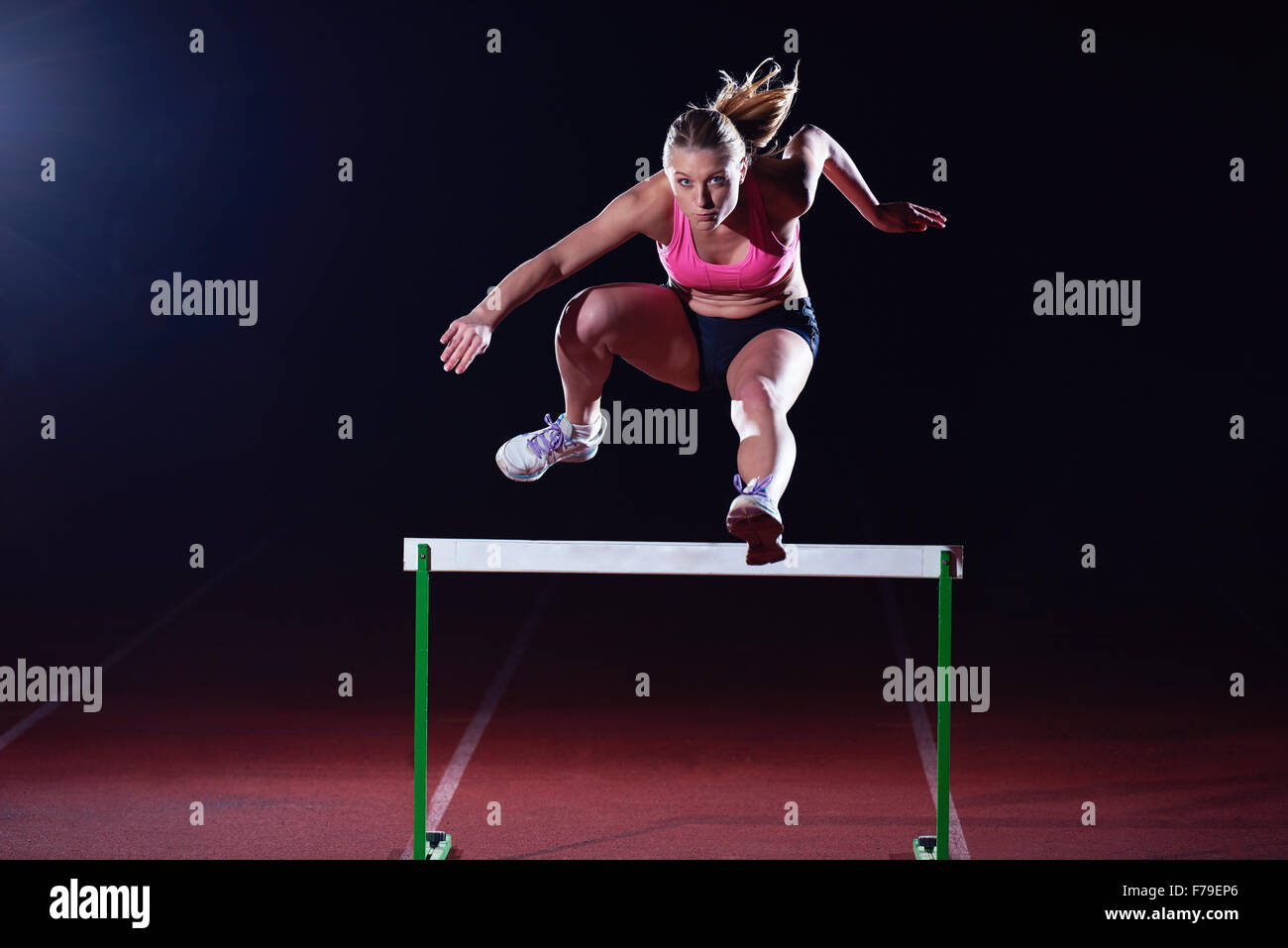 Woman jumping over hurdles hi-res stock photography and images - Alamy