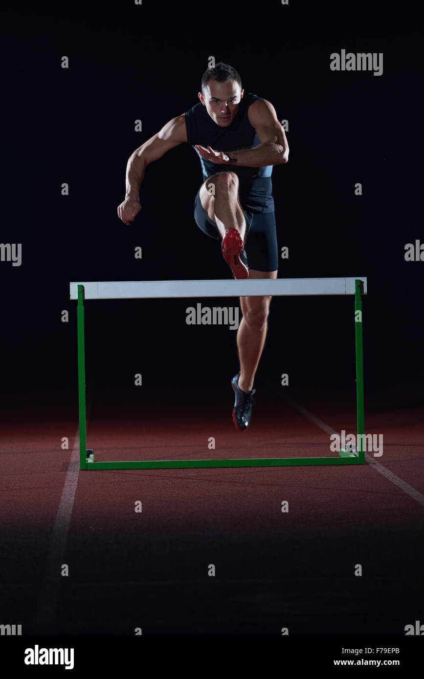 man athlete jumping over a hurdles on athletics race track Stock Photo ...