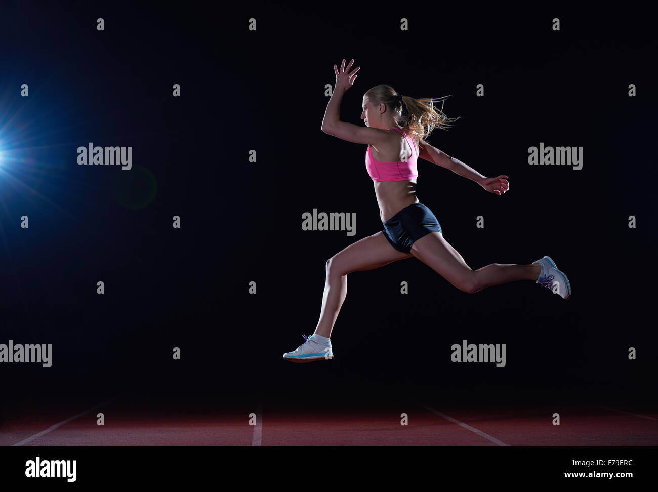 Athletic woman running onrace track Stock Photo - Alamy