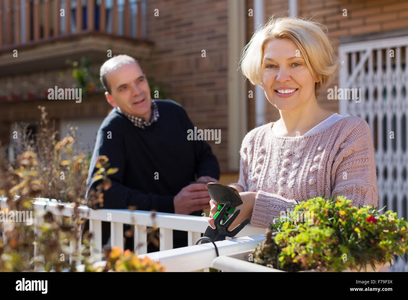 Mature smiling female talking with male neighbor at balcon Stock Photo ...