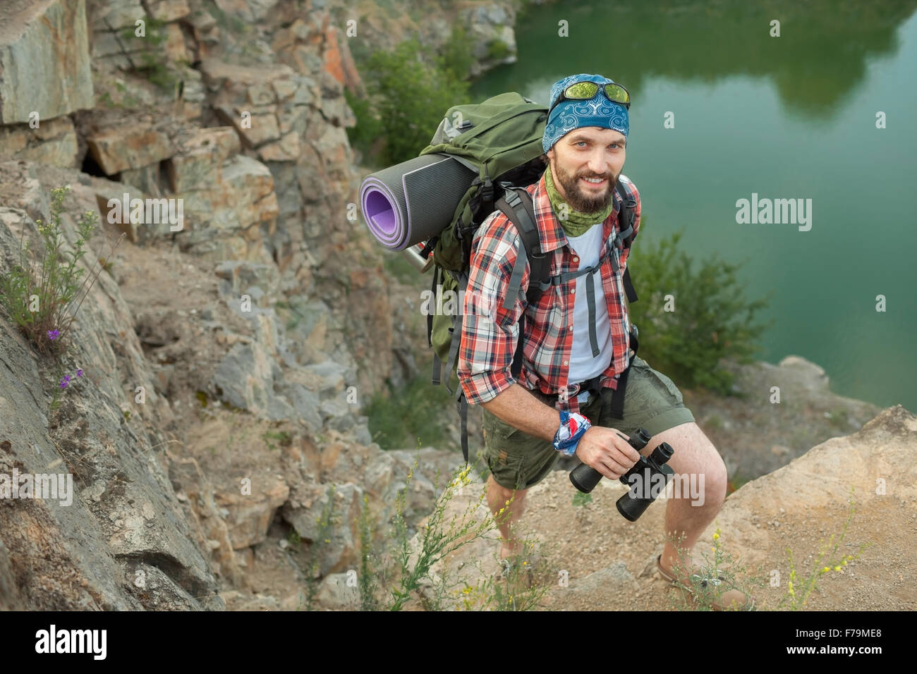 Young caucasian man with backpack climbing the rock Stock Photo - Alamy