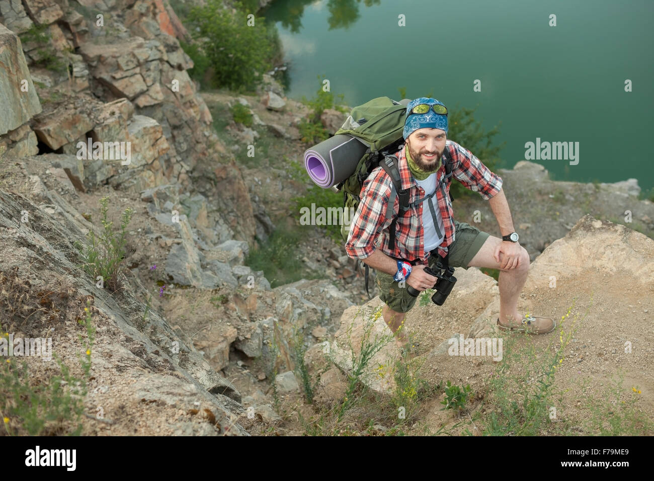 Young caucasian man with backpack climbing the rock Stock Photo - Alamy