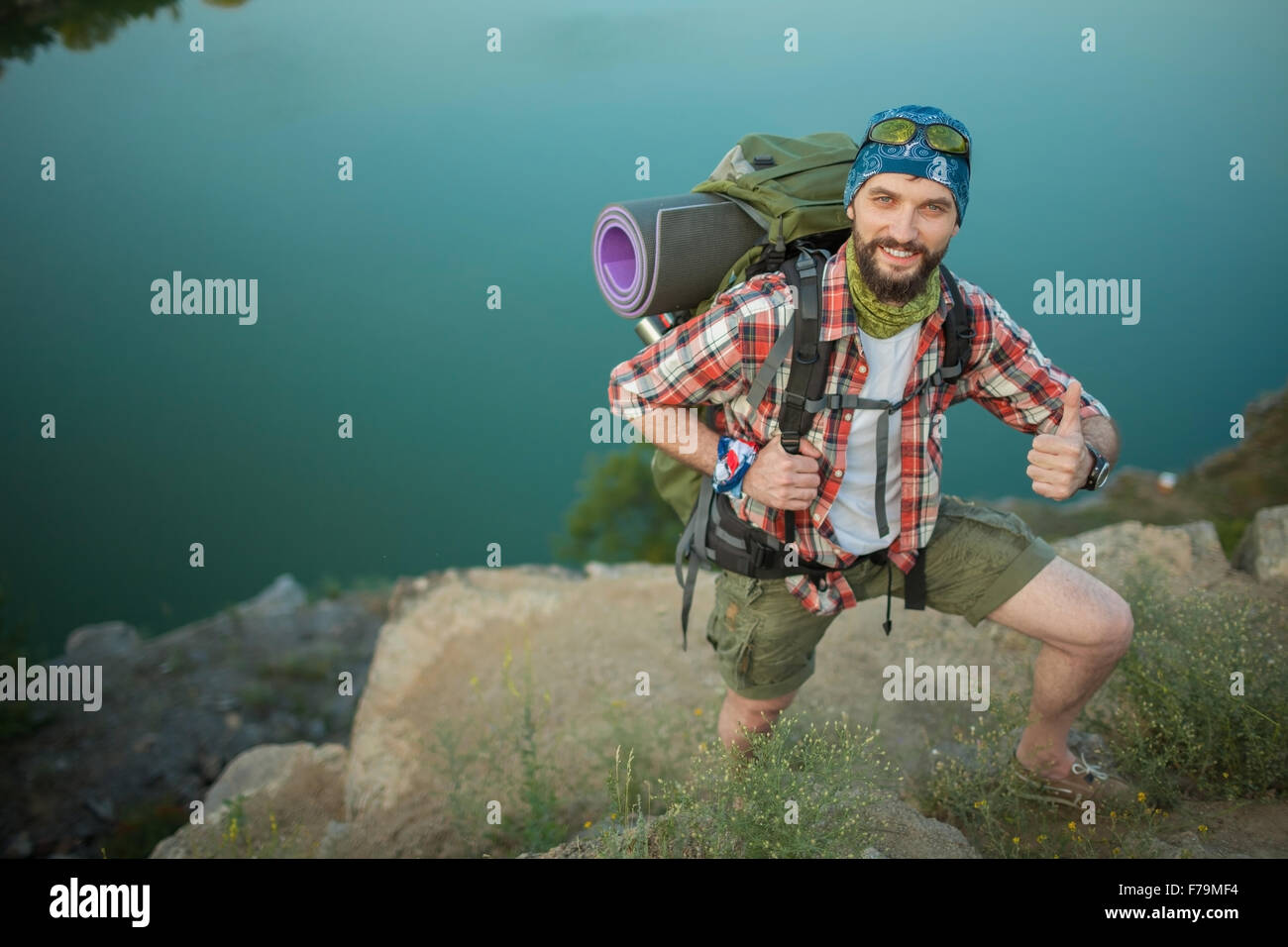Young caucasian man with backpack climbing the rock Stock Photo - Alamy