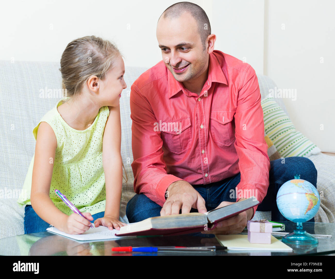 Portrait of smiling dad helping schoolgirl to study at home Stock Photo ...