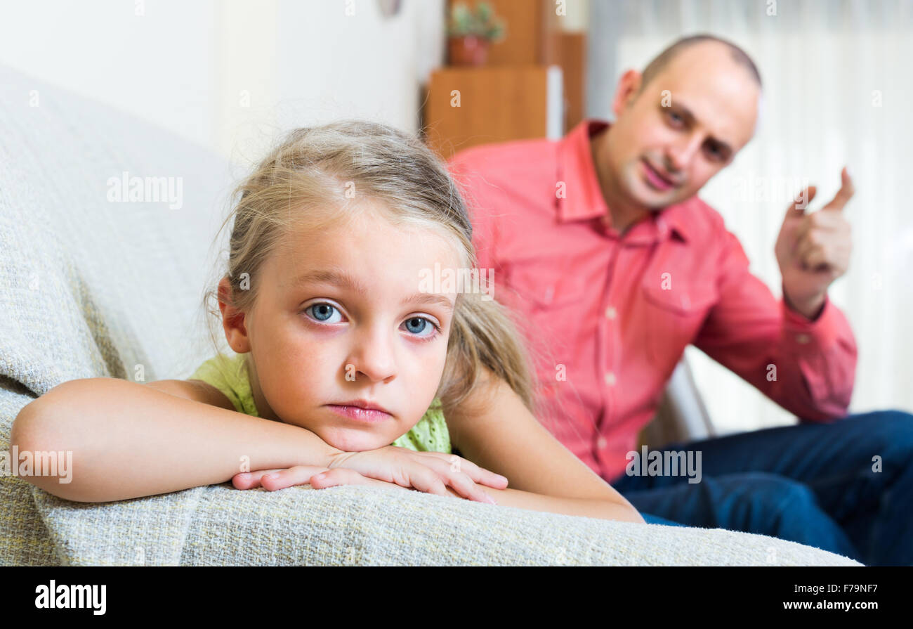 Serious father rebuking small daughter for offence in interior Stock ...