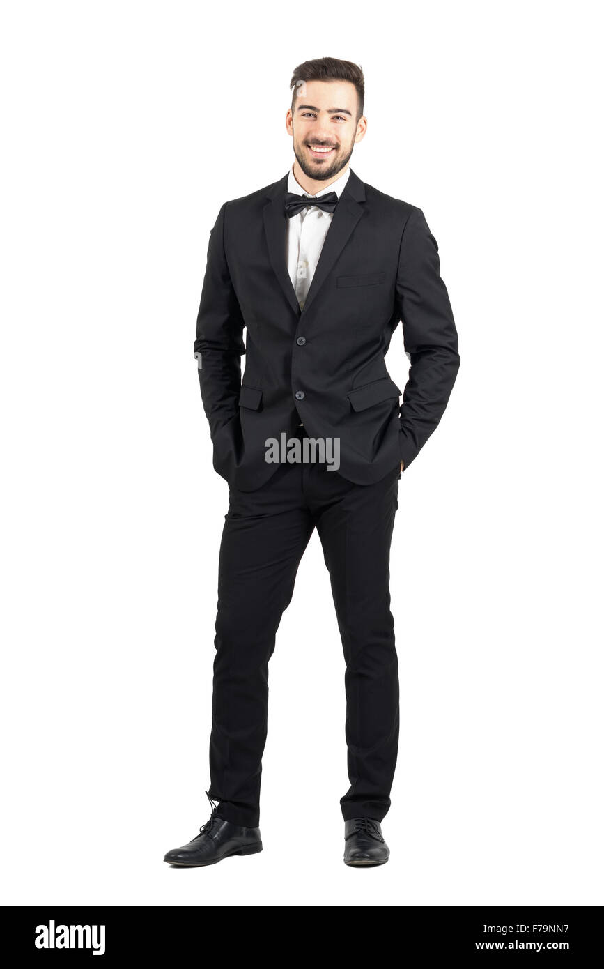 Laughing happy young man in tuxedo with bow tie looking at camera. Full ...