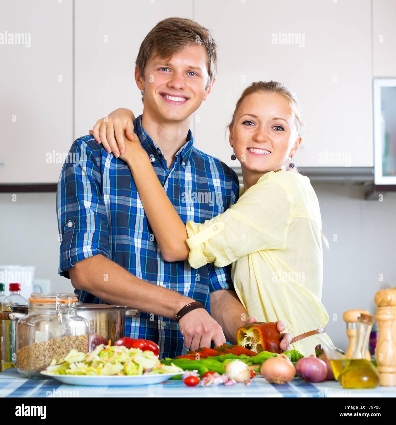Happy husband helping young beautiful wife to prepare healthy dinner ...