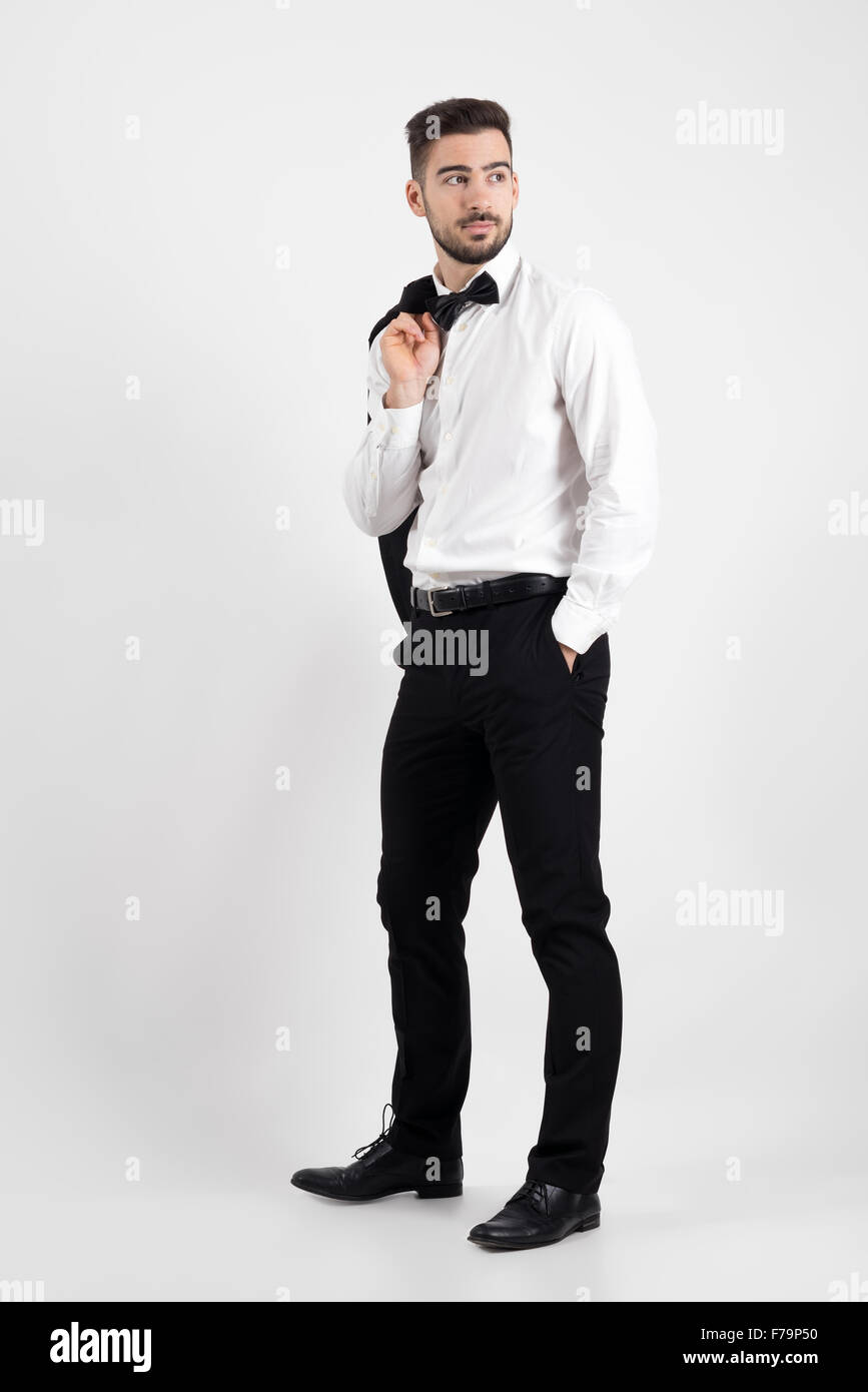 Side view of elegant man holding suit jacket over his shoulder looking ...