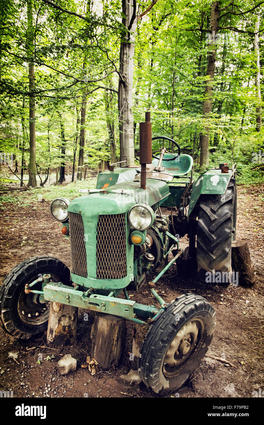 Old broken tractor in the forest. Agricultural machine Stock Photo - Alamy