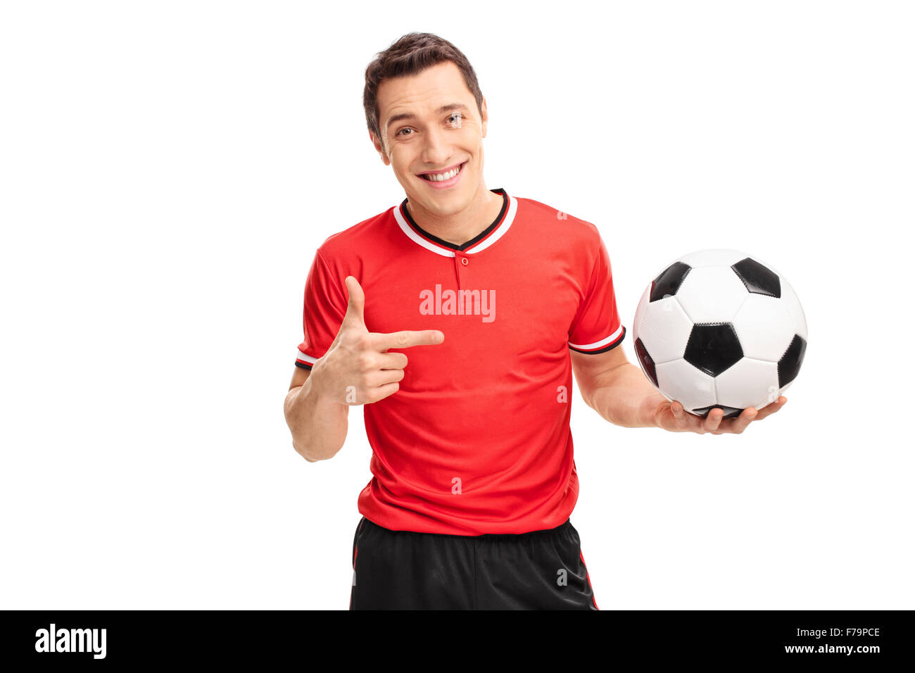 Young football player holding a ball in one hand and pointing towards ...