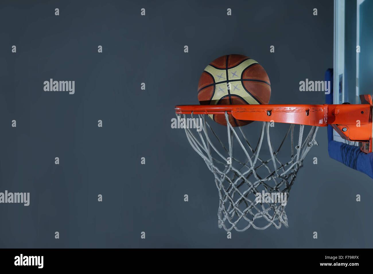 Basketball ball, board and net on grey background in gym indoor Stock ...