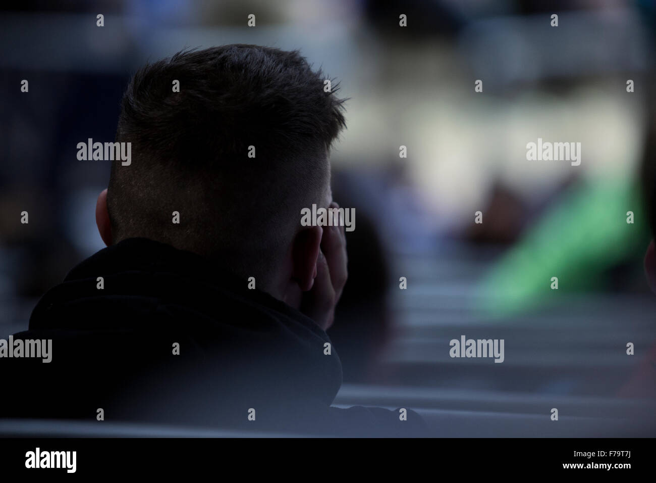 A spectator looks bored on the game that takes place in front of him ...