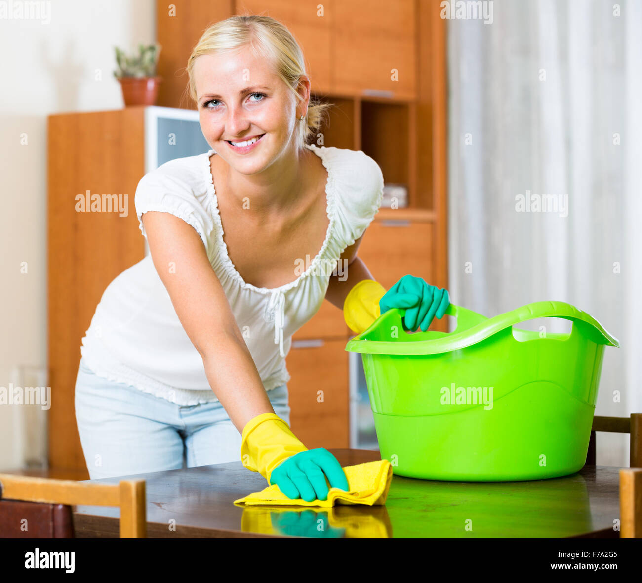 Positive housewife doing regular clean-up in house Stock Photo - Alamy