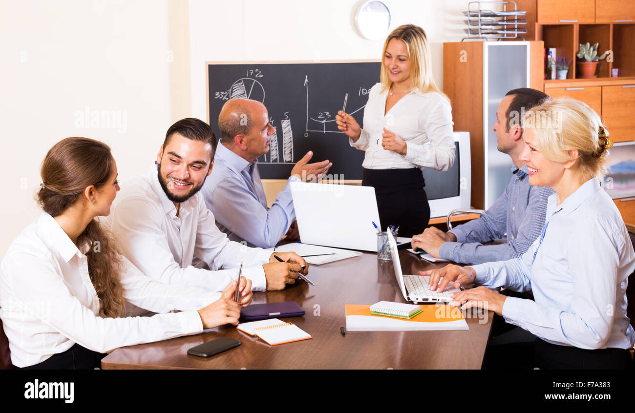 Positive office staff gathered in the modern conference hall for the ...