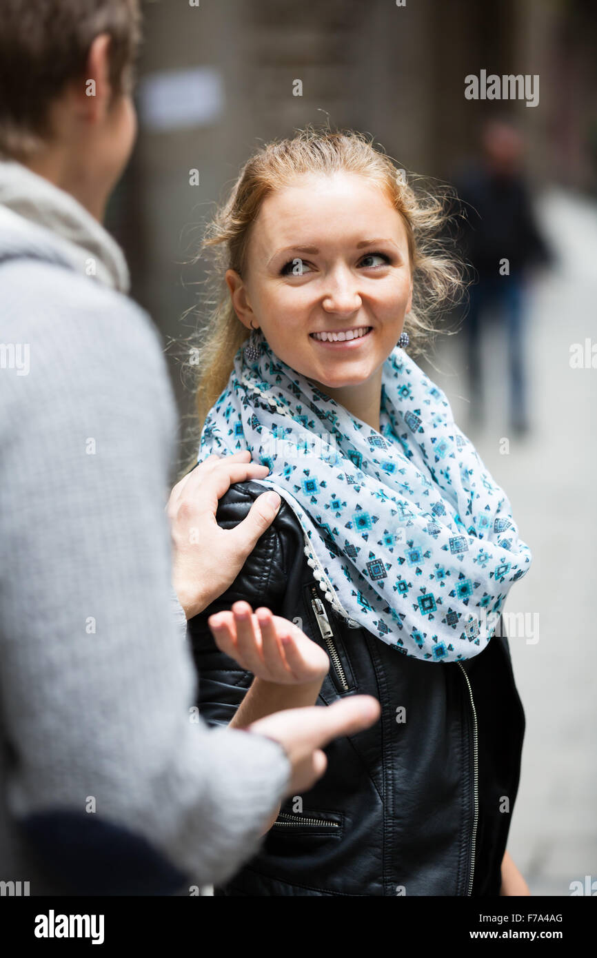 Nice-looking male student chasing pleased girl on outdoor date Stock ...
