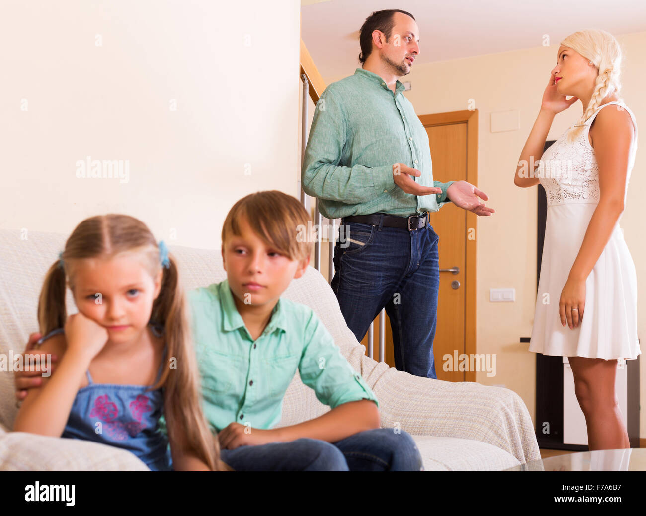 Sad young siblings waiting when parents stop screaming indoors Stock ...