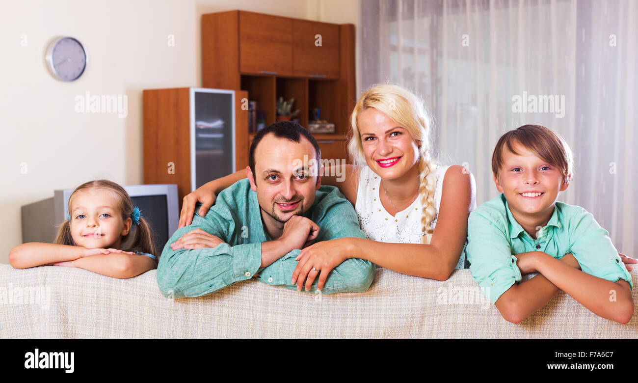 Portrait of smiling middle class family with two children at home ...