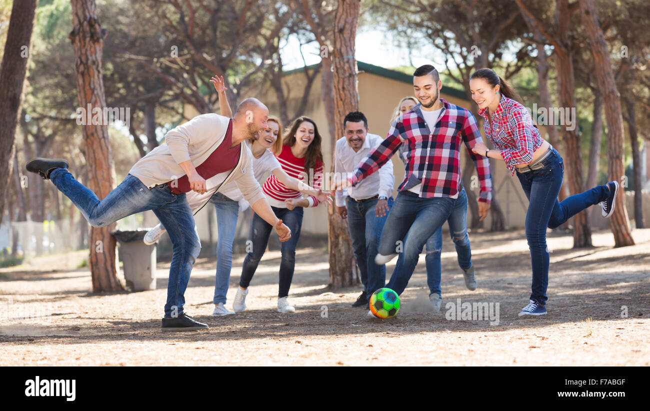 Several cheerful friends running with a ball and laughing Stock Photo ...