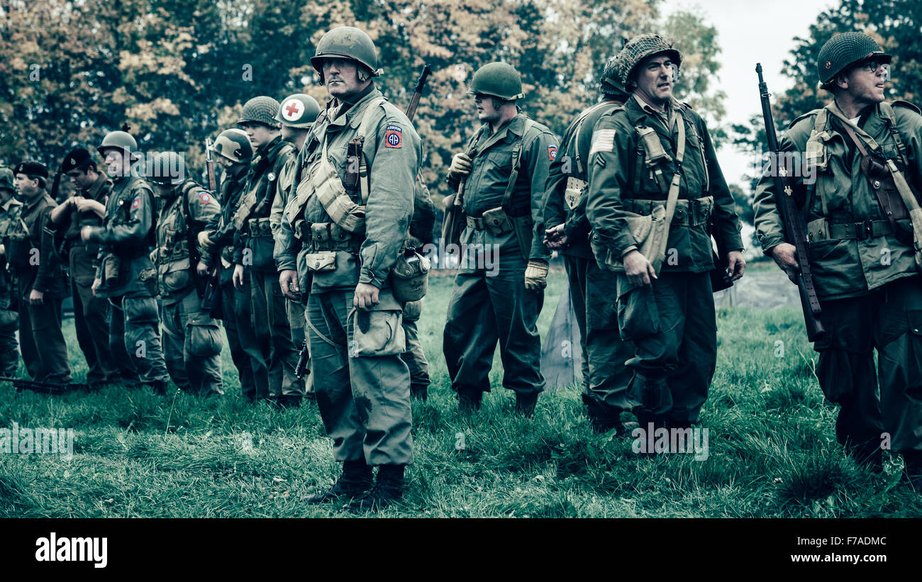 Multiple reenactment soldiers lined up on battlefield, one looks to ...