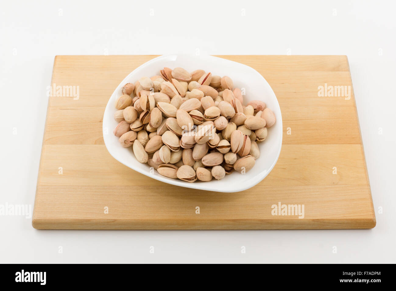 the plateful of pistachios costs on a plate on a white background Stock ...
