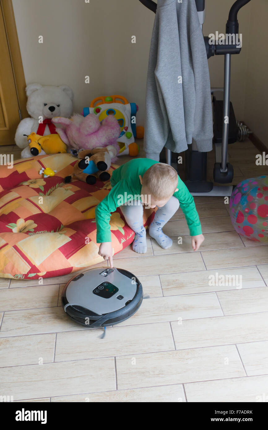 the little boy watches the robot the vacuum cleaner Stock Photo - Alamy