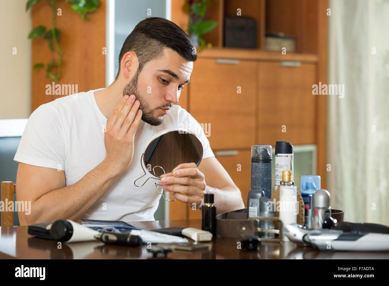 Young man checks in the mirror of your problem skin Stock Photo - Alamy