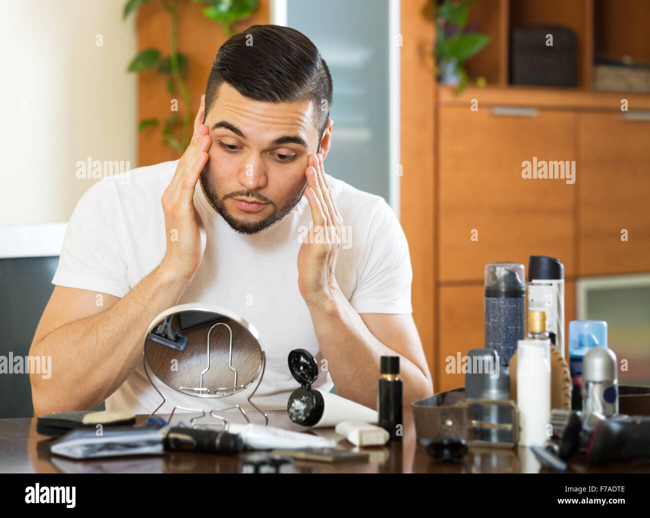 sad man applying cream from the tube Stock Photo - Alamy