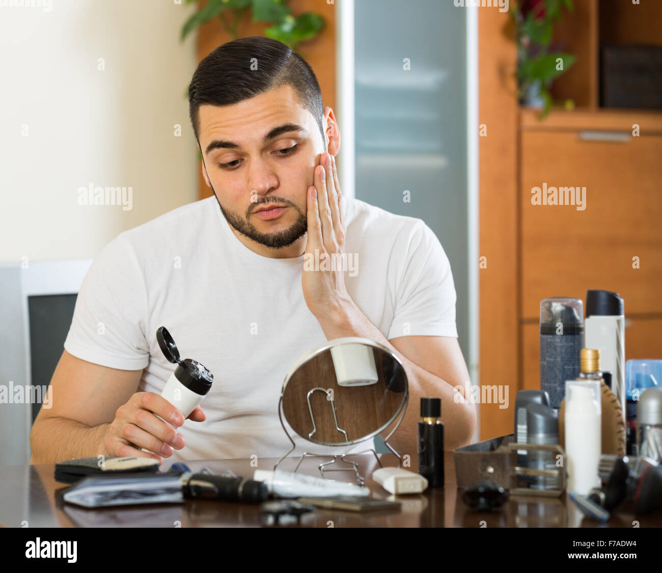 Handsome man 20 years old applying facial cream at home Stock Photo - Alamy