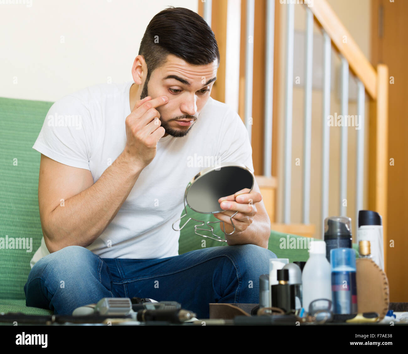 adult guy looking at his problematic skin in a mirror Stock Photo - Alamy