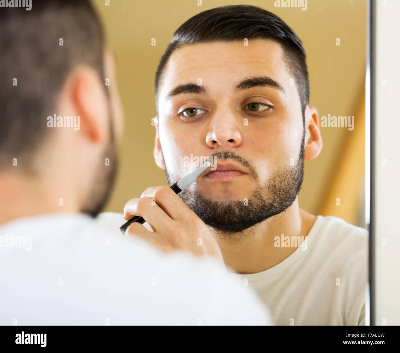 handsome guy shaving by electric shaver at home Stock Photo - Alamy