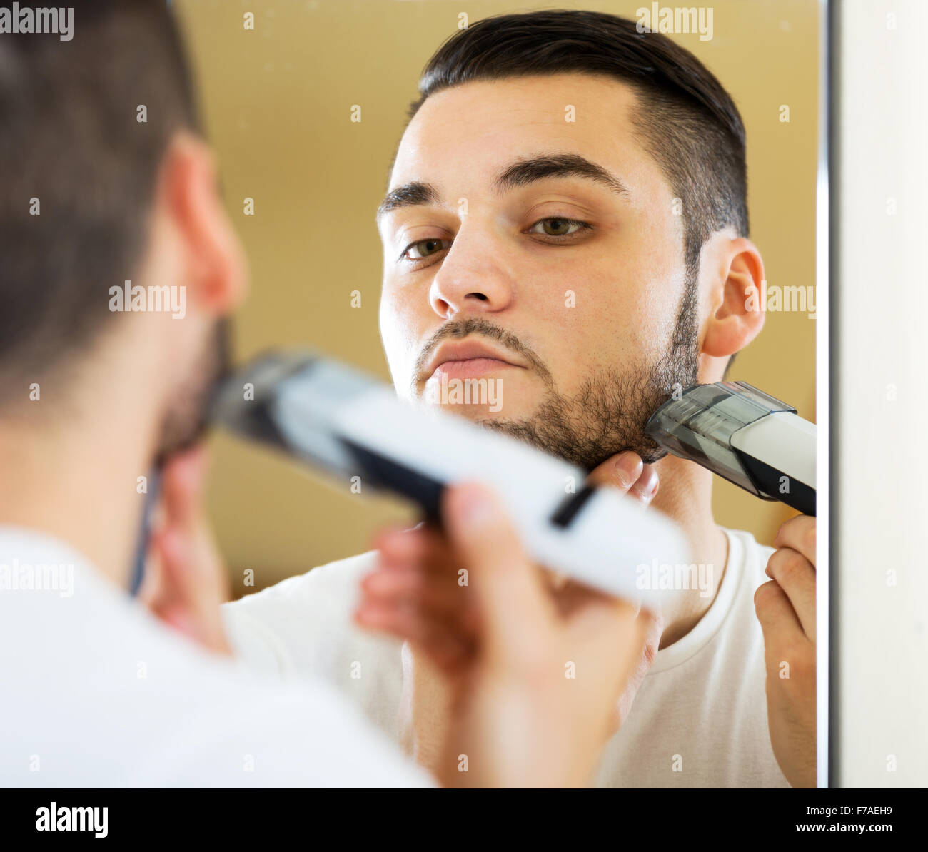 portrait handsome guy shaving by electric shaver at home Stock Photo ...