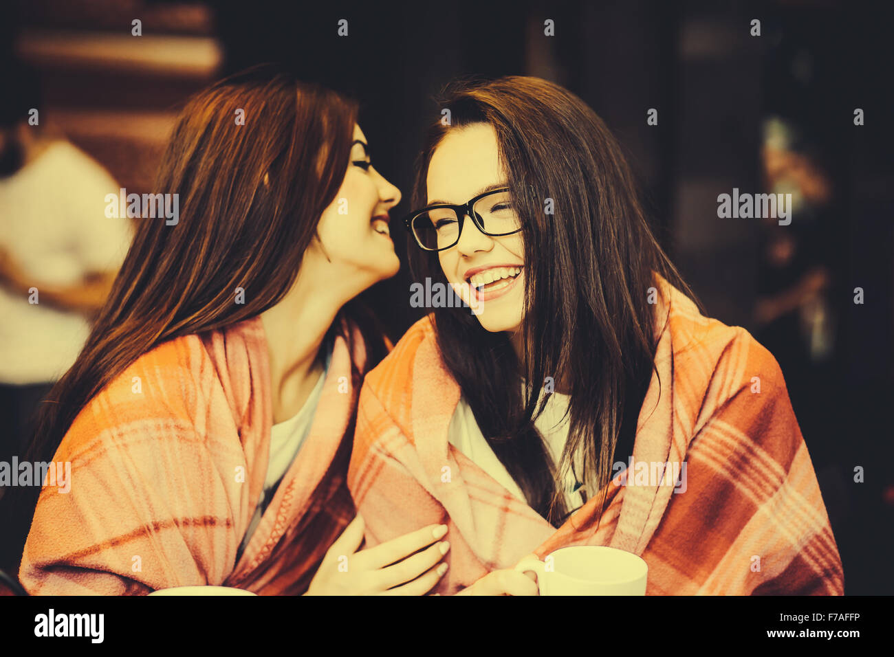 Two young and beautiful girls gossiping Stock Photo - Alamy