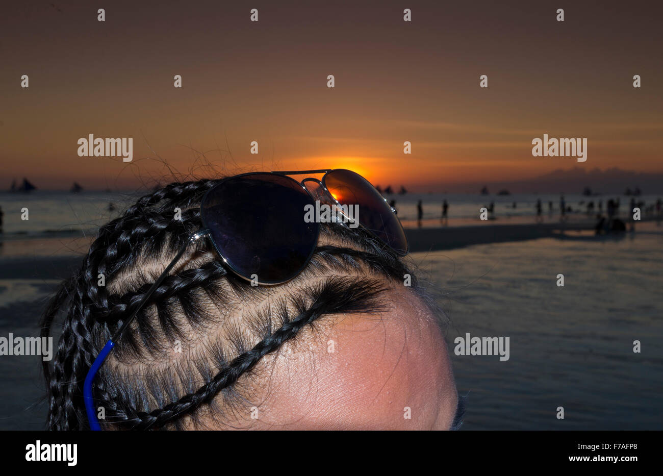 braided hair with sunglasses during a beautiful tropical sunset Stock ...