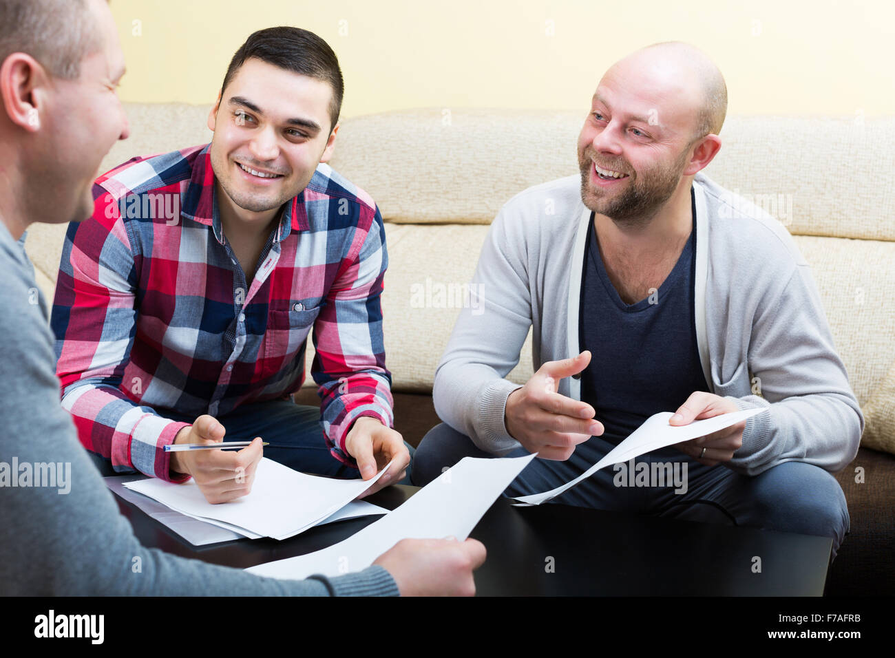 Satisfied clients sitting at the table with papers Stock Photo - Alamy