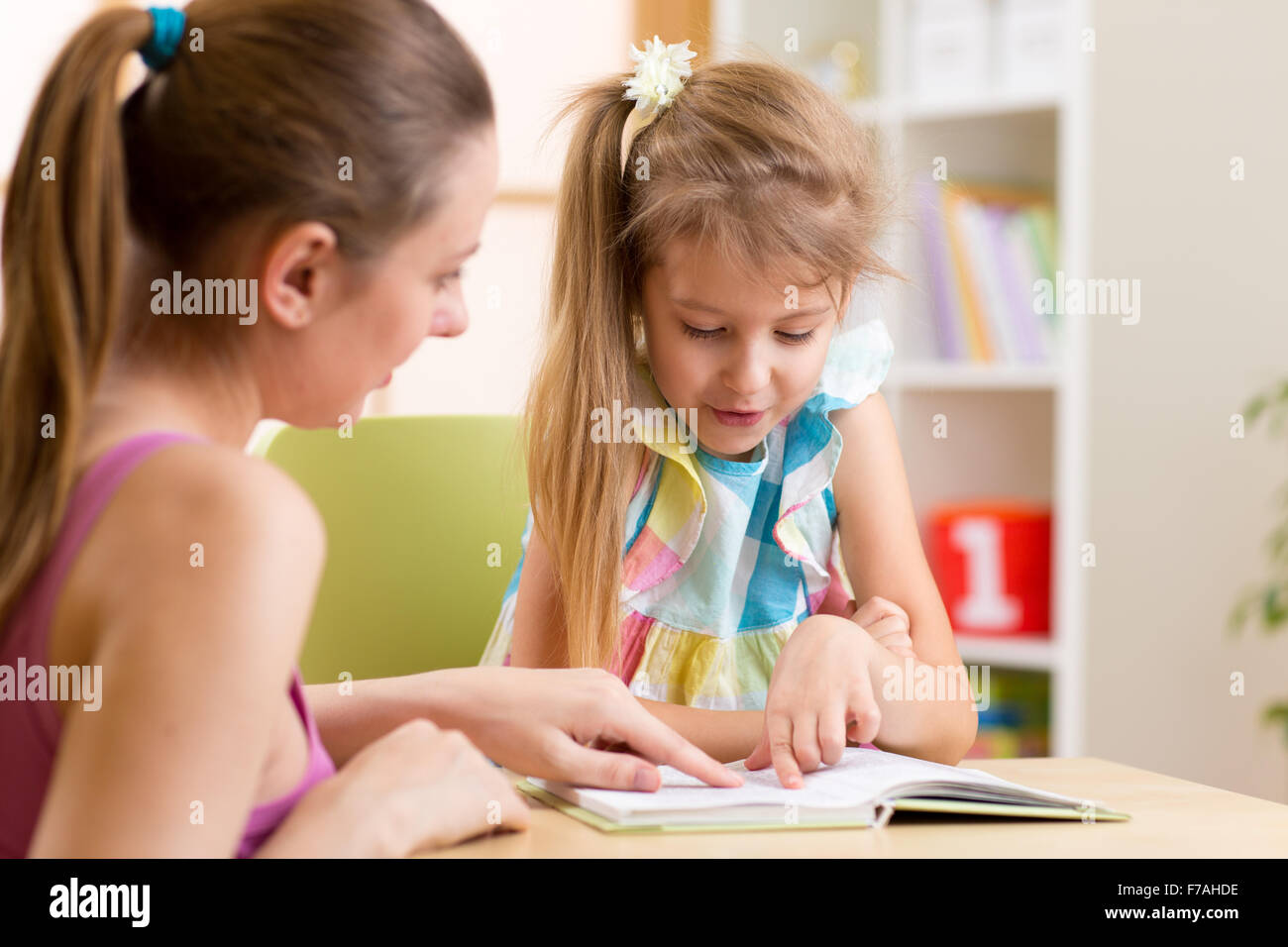 Mother teaching child daughter to reading Stock Photo - Alamy