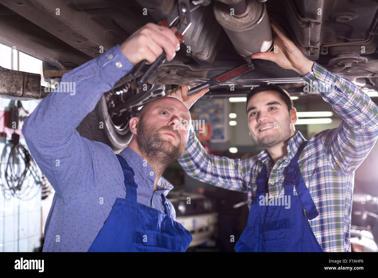Two people fixing car tire leak Stock Photo - Alamy