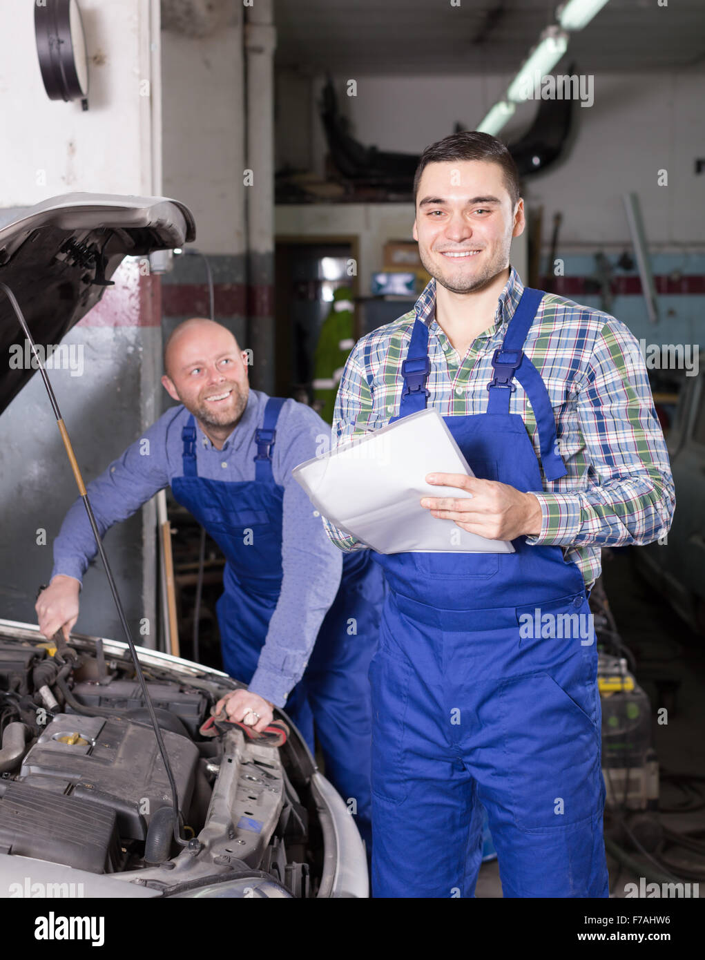 Workman calculates the cost of work in auto repair shop Stock Photo - Alamy