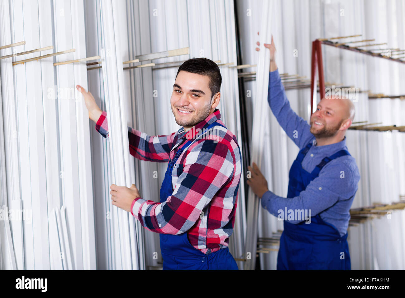 Smiling workmen choosing PVC window profile at factory Stock Photo - Alamy