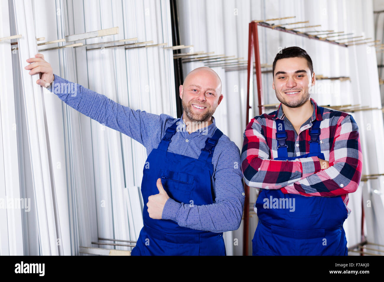 Two happy adult workers posing in PVC shop Stock Photo - Alamy