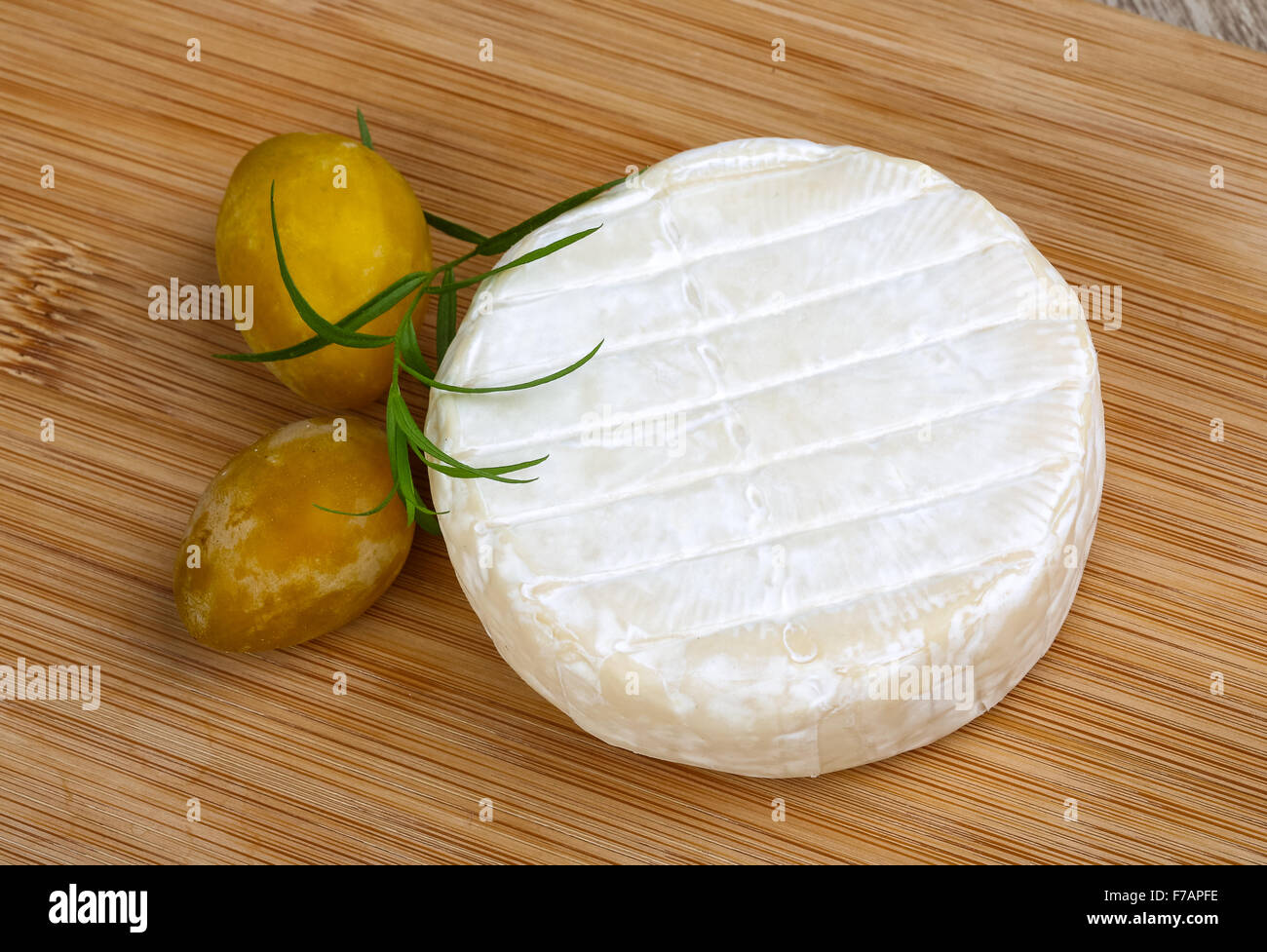 Round Brie cheese with yellow plums and estragon Stock Photo - Alamy